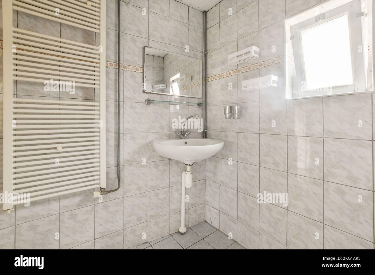 Shower faucets attached to tiled wall near curtail in washroom at home ...