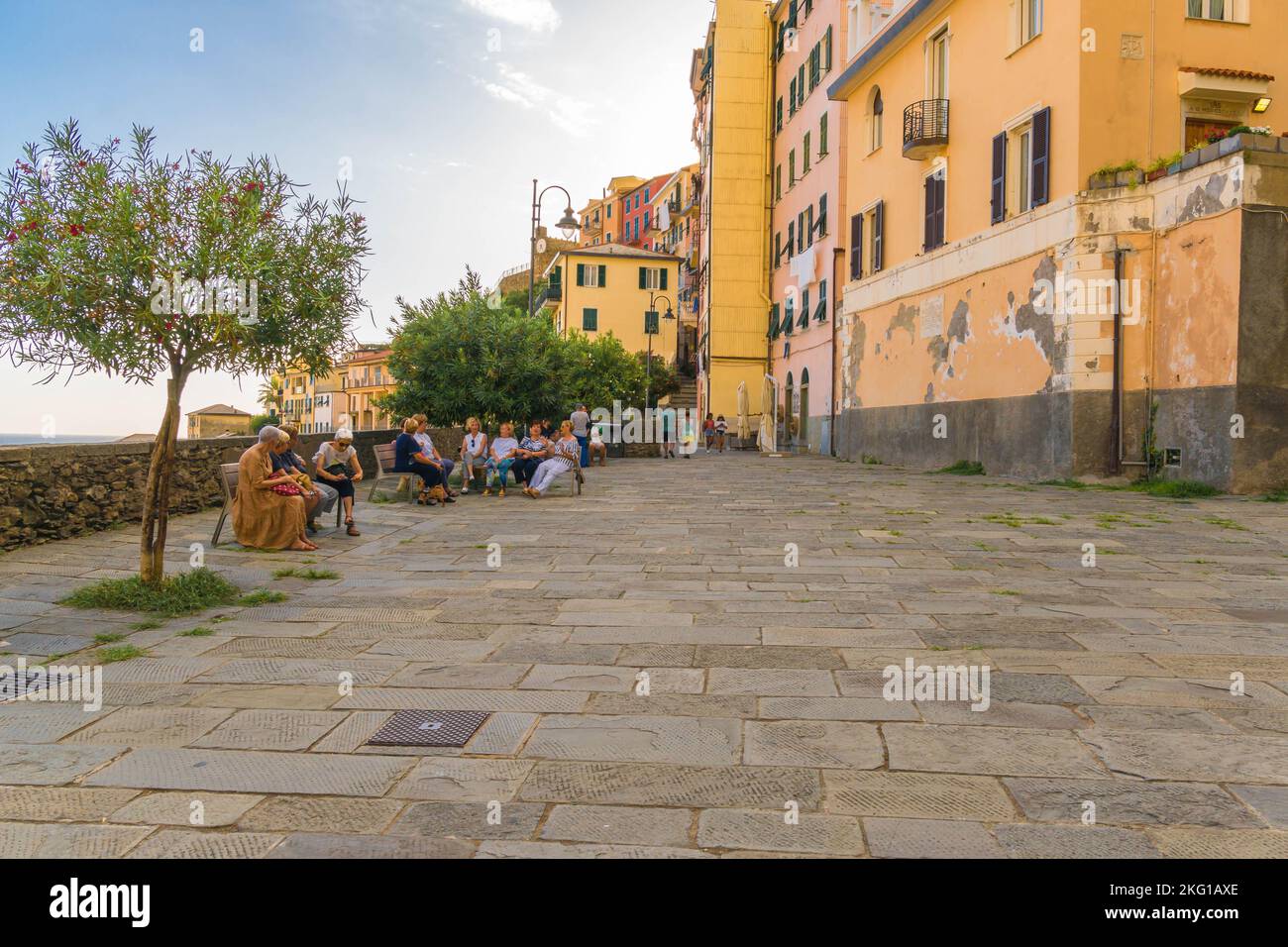 Locals passing the day sat on benches and chatting in the Via Pecunia ...
