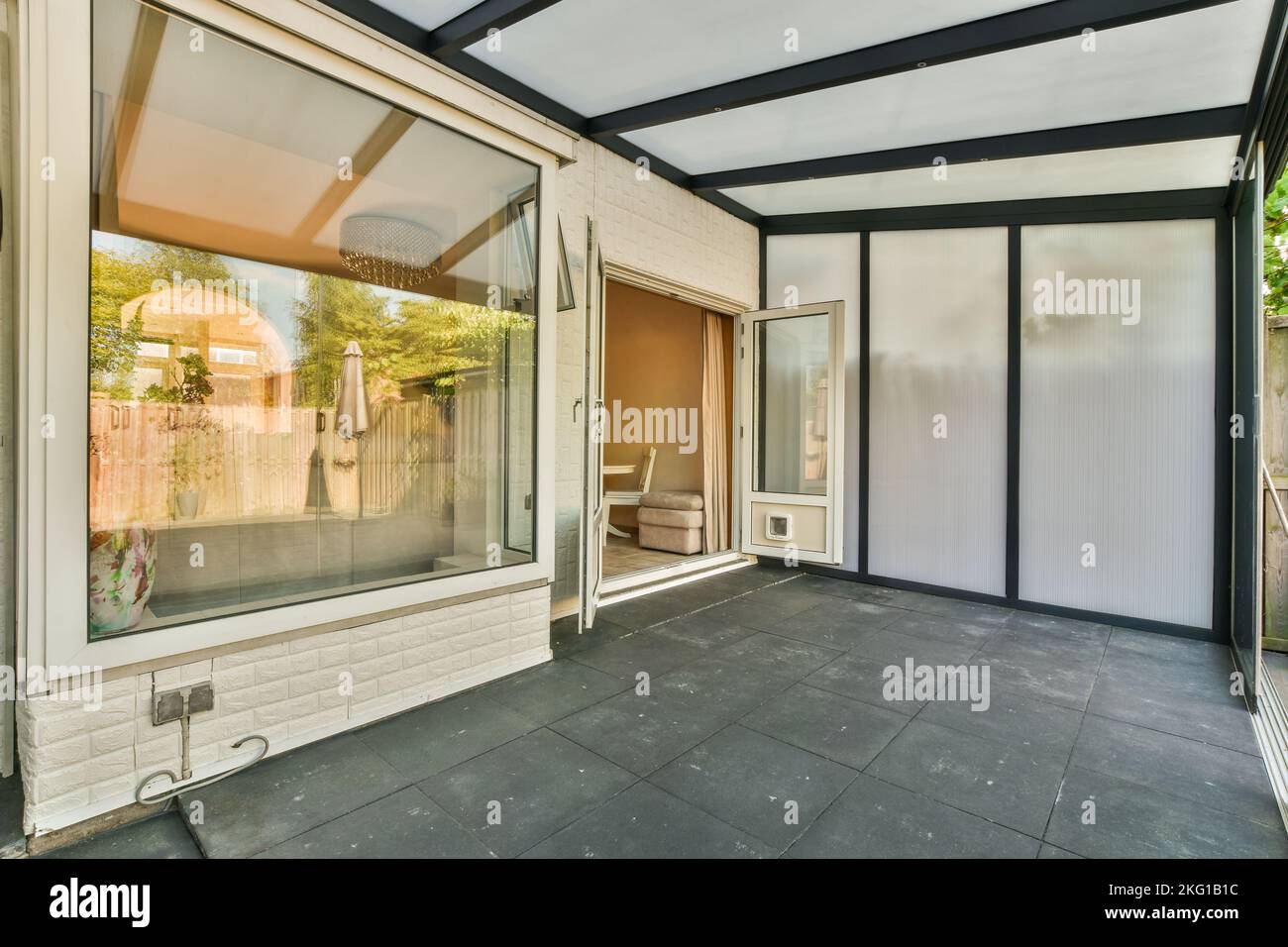 Opened glass door leading into terrace from stylish living room in ...