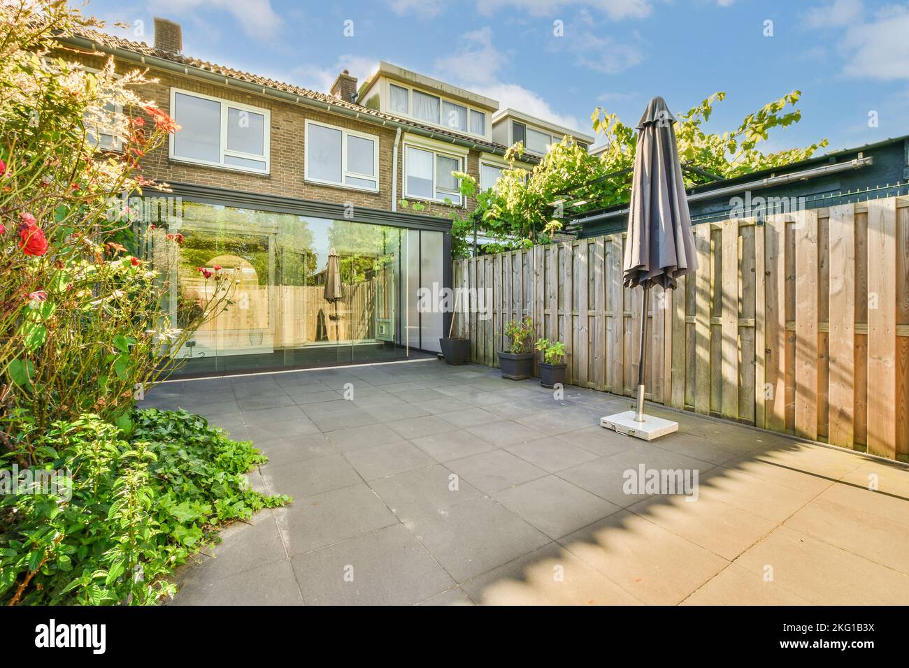 Simple small patio with small garden near wooden fence Stock Photo - Alamy