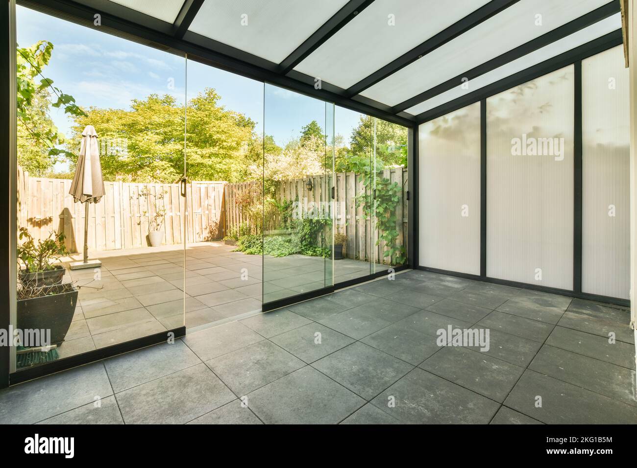 Opened glass door leading into terrace from stylish living room in ...