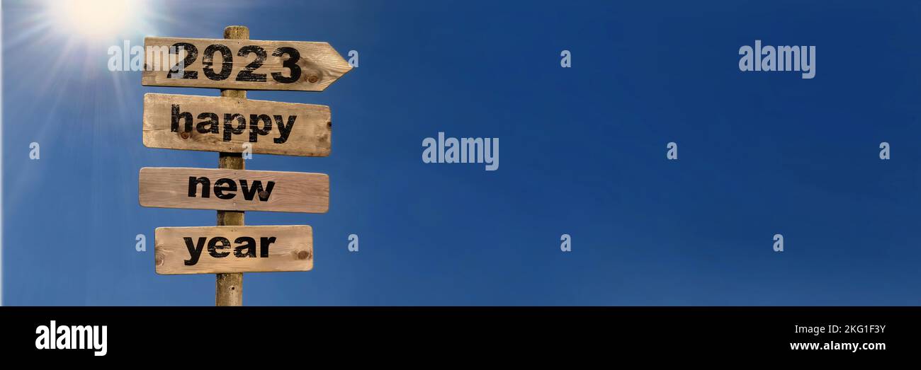 2023 happy new year writting on a wooden postsign on sunny blue sky ...