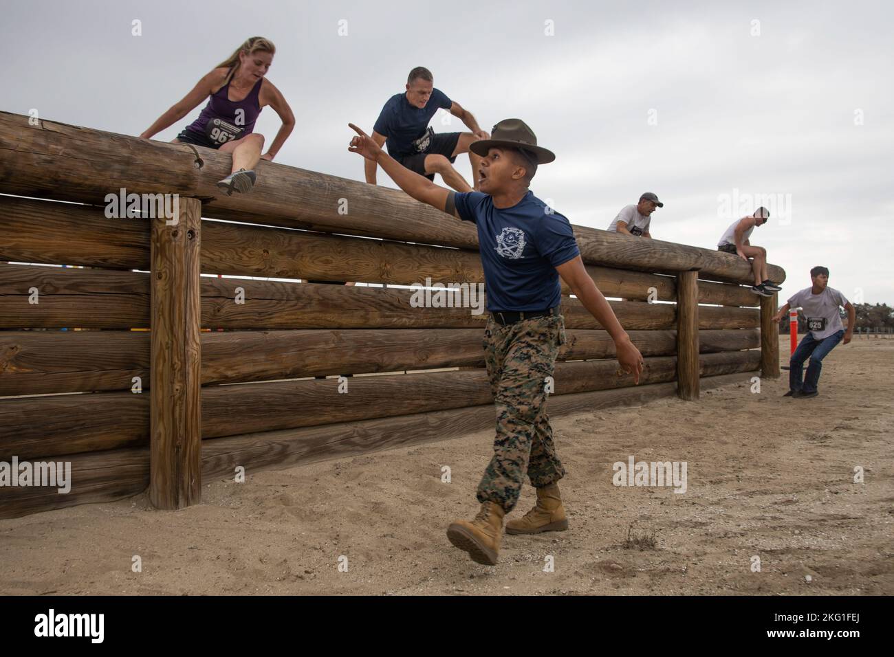 Boot Camp Challenge participants jump over a wall in a race at Marine Corps Recruit Depot San ...