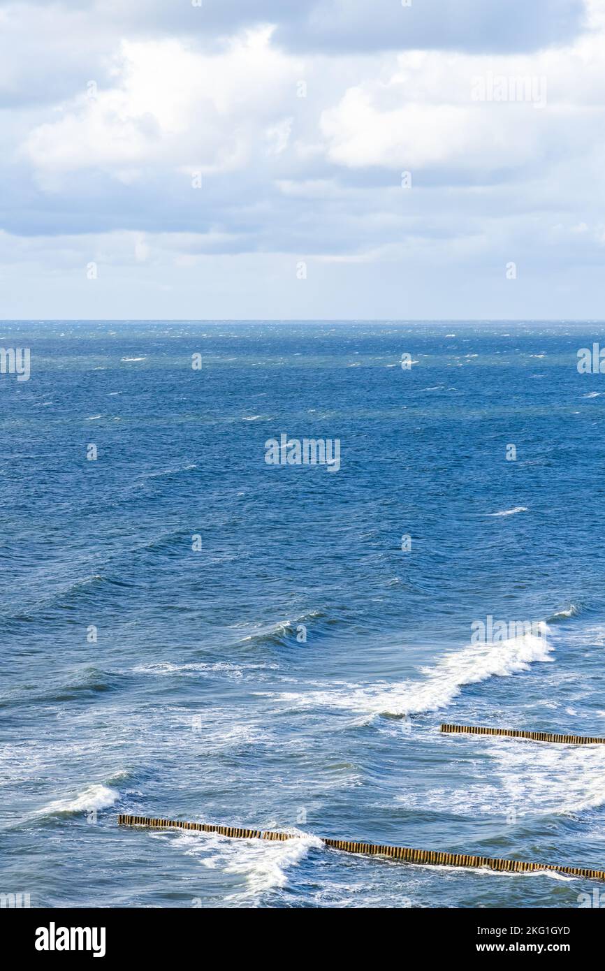 Baltic Sea view with breakwaters under cloudy sky on a sunny day ...