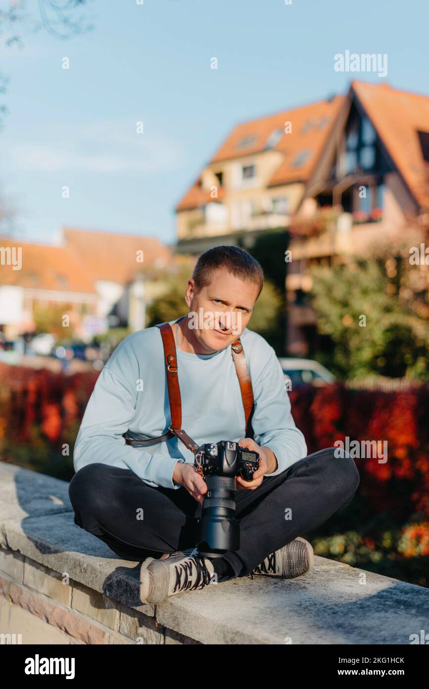 Man Sitting in Old European City And Holding Photo Camera. Contemporary ...