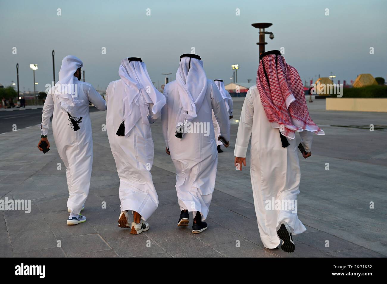 Doha, Katar. 20th Nov, 2022. Men, Qataris in traditional robes walk ...