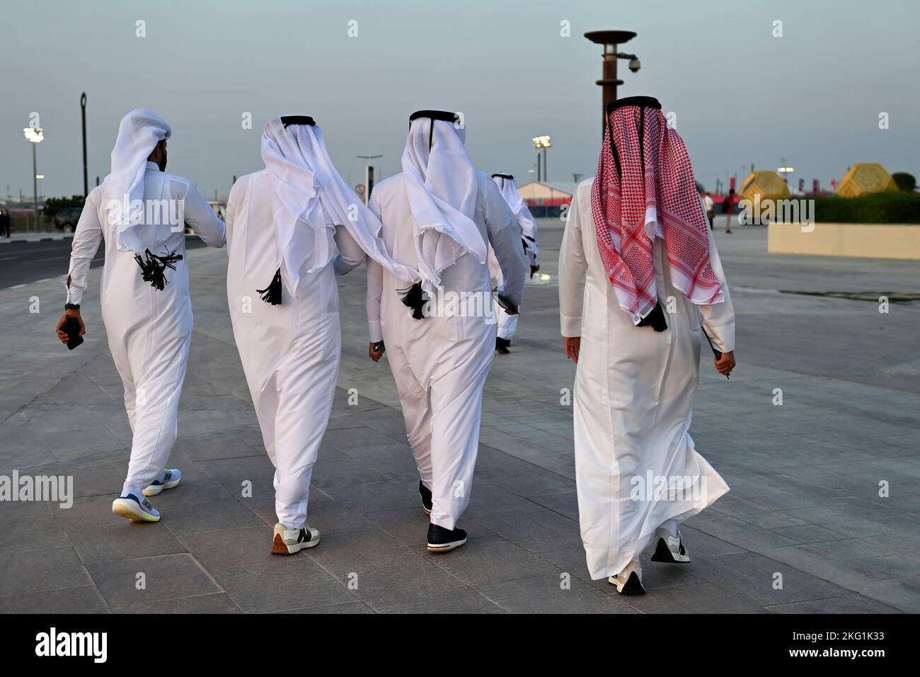 Doha, Katar. 20th Nov, 2022. Men, Qataris in traditional robes walk ...