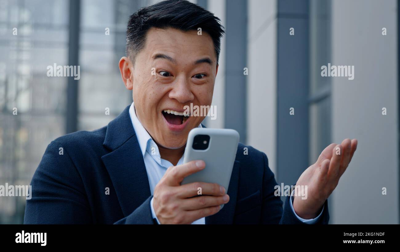 Close up Asian happy surprised man emotionally enjoys success good news ...