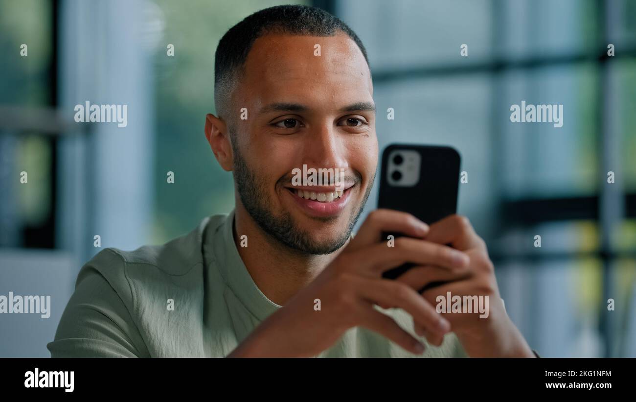 African American businessman browsing smartphone indoors. Multiracial ...