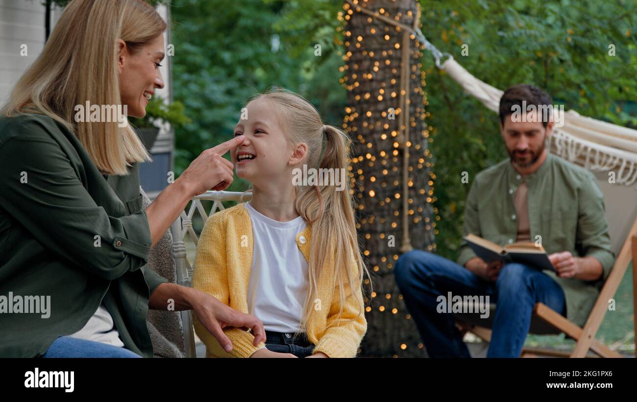 Caucasian mother talking laughing with funny daughter touching baby ...