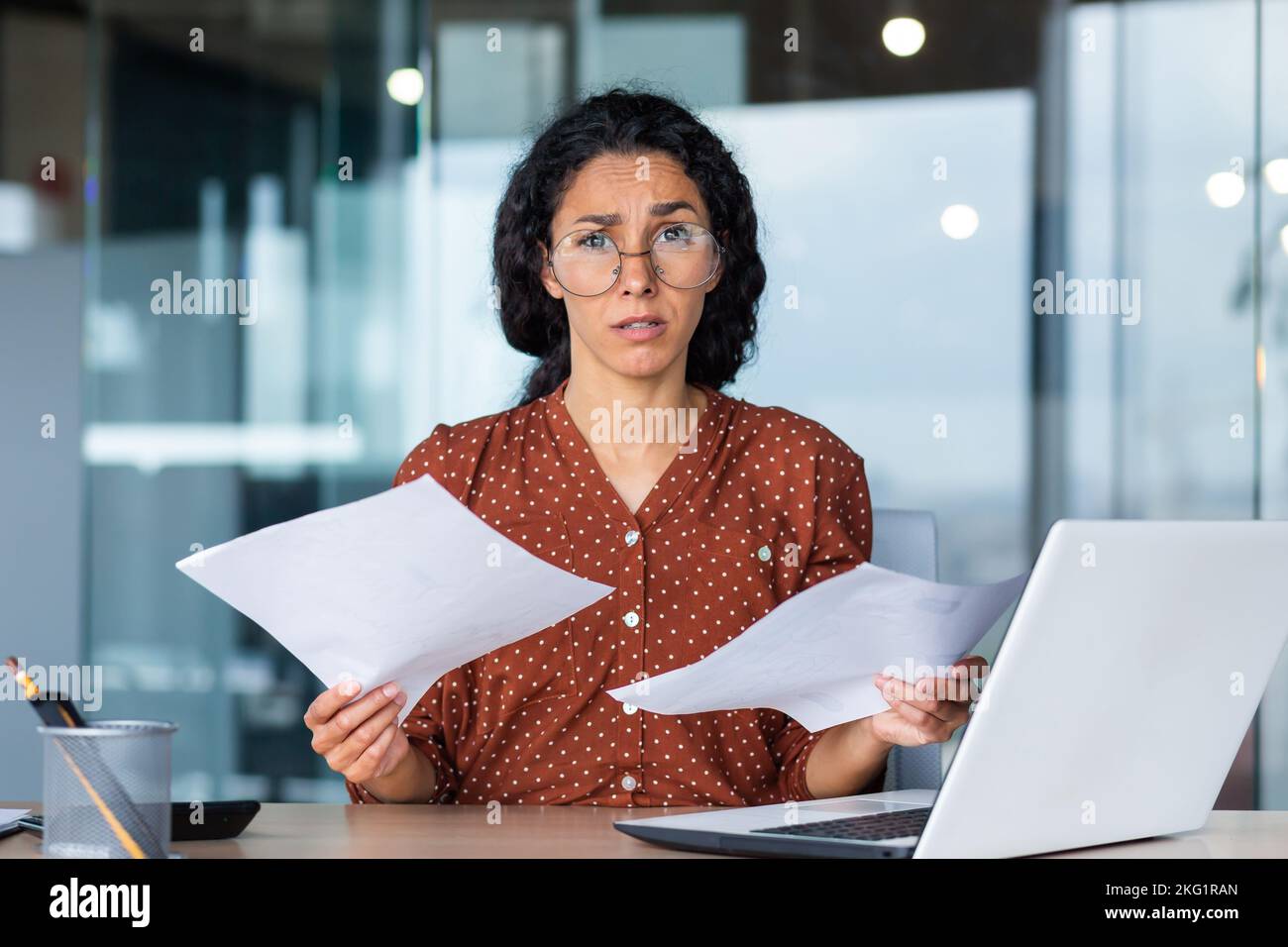 Sad and disappointed woman with documents looking at camera, portrait ...