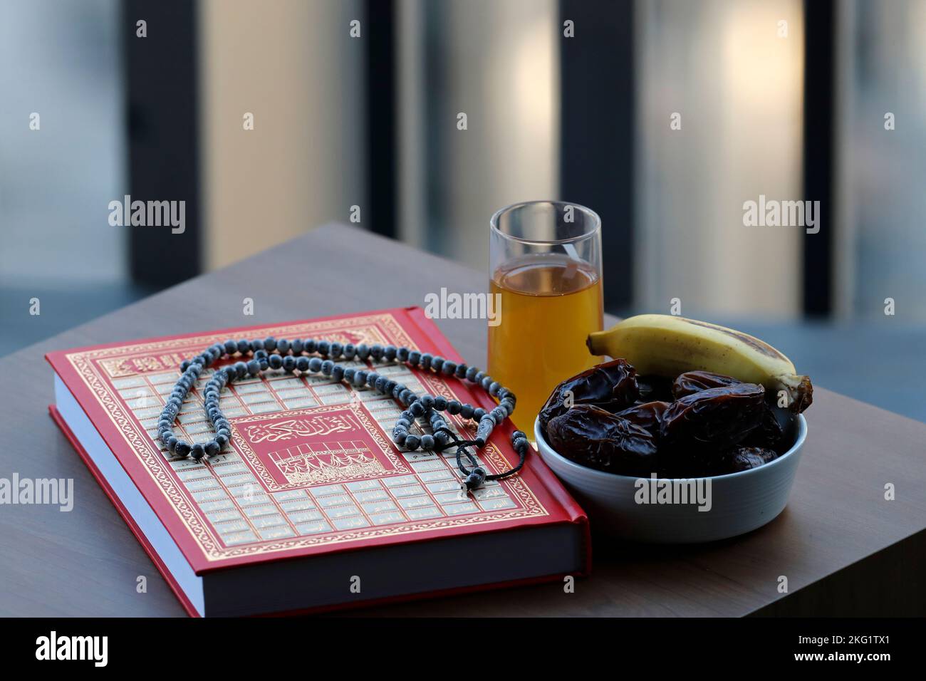Holy Quran in arabic, muslim prayer beads, glass of tea and fresh dates ...