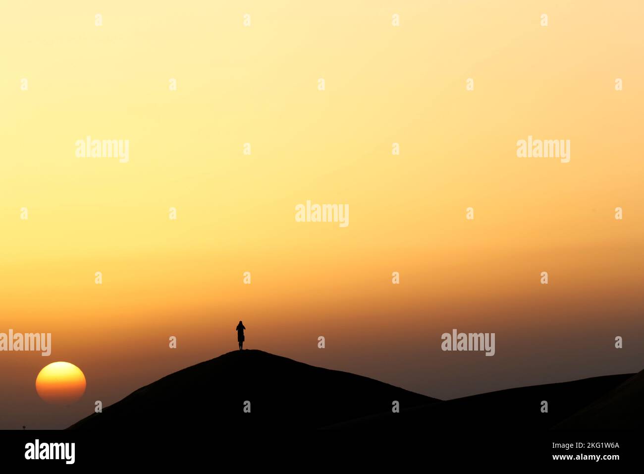 Silhouette on sand dune. Sunset meditation in the desert. Concept for ...
