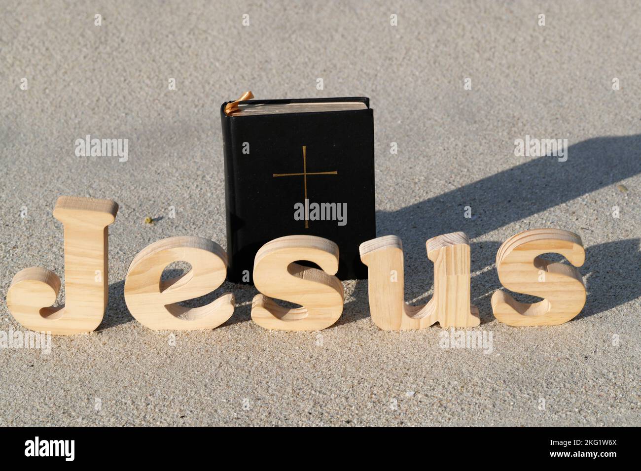 Wooden letters forming the word Jesus with a Bible on a background of ...