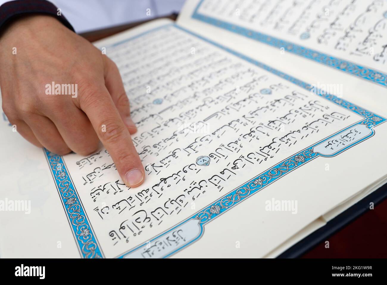 Muslim reading the Holy Quran. Close up on hand Stock Photo - Alamy