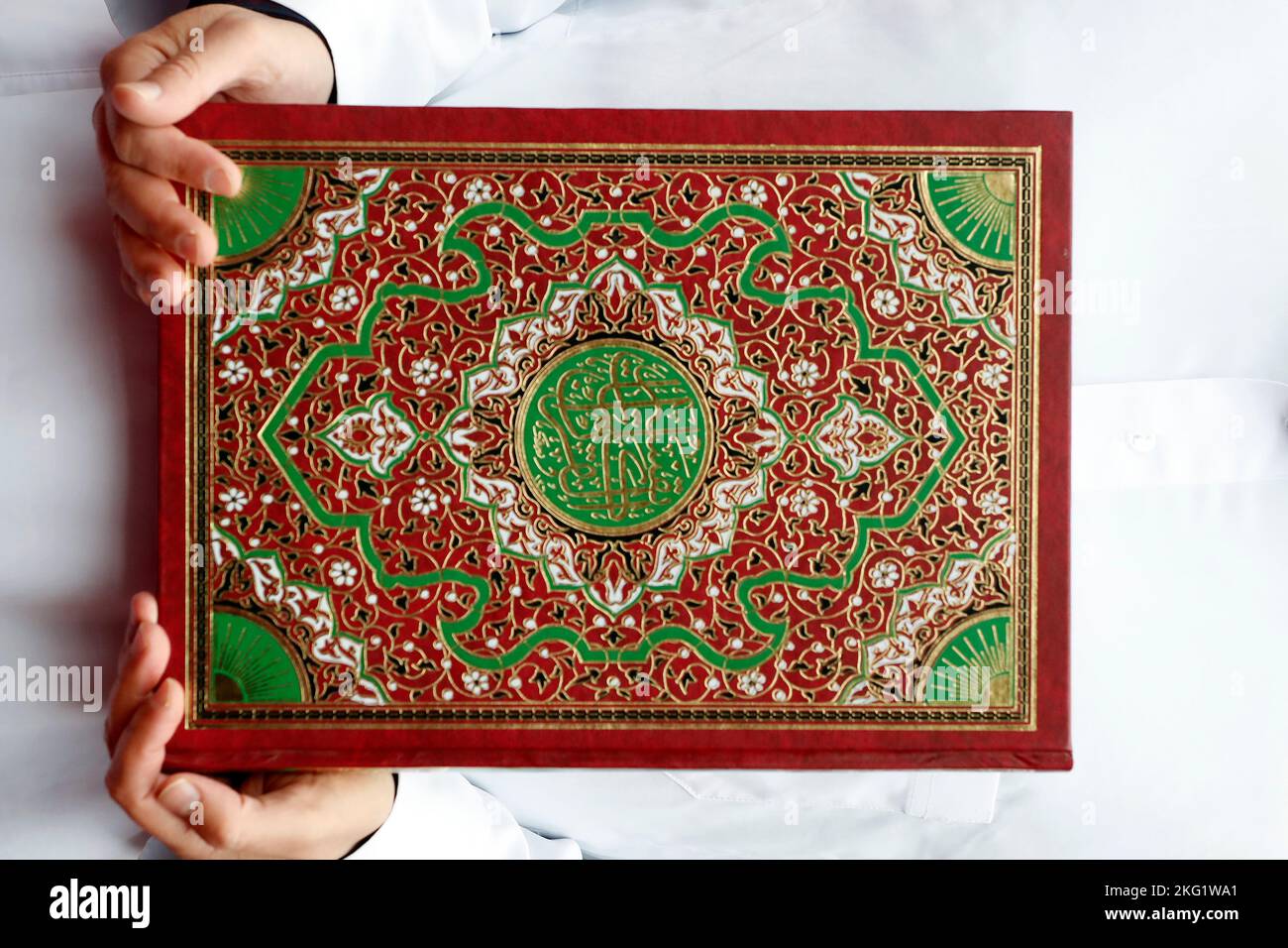 Holy Quran in hands. Close up on the cover with calligraphy Stock Photo ...