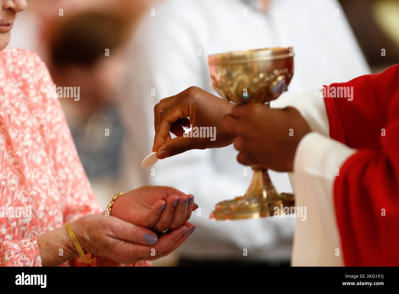 Sunday mass in a catholic parish. Priest giving Holy Communion ...