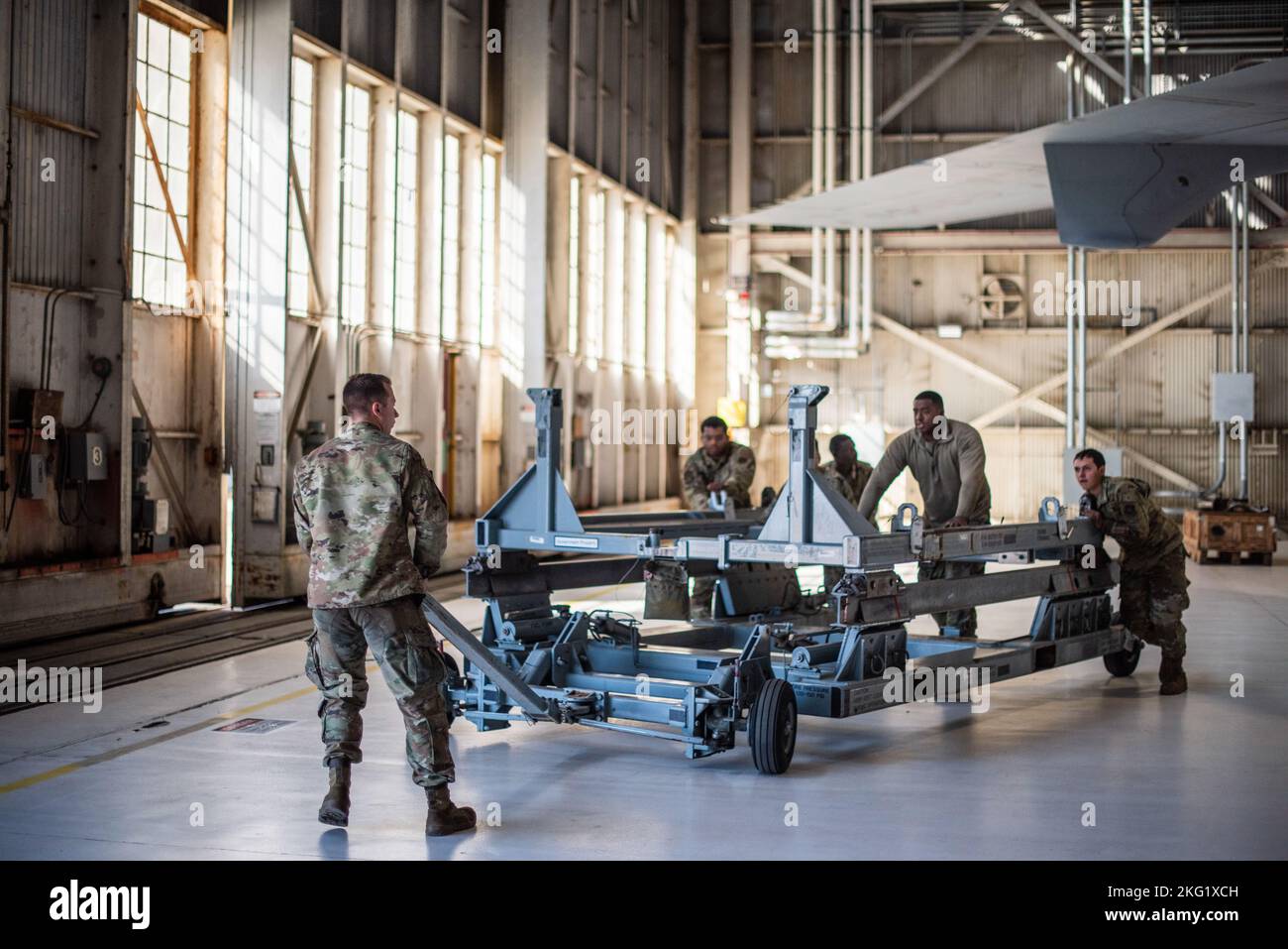 U.S. Airmen with the 660th Aircraft Maintenance Squadron move an engine ...