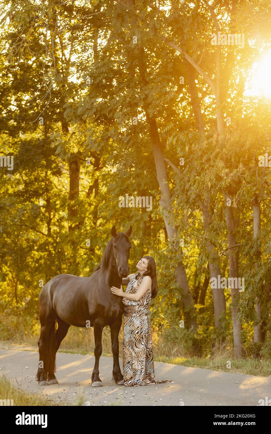 young woman with friesian mare Stock Photo - Alamy