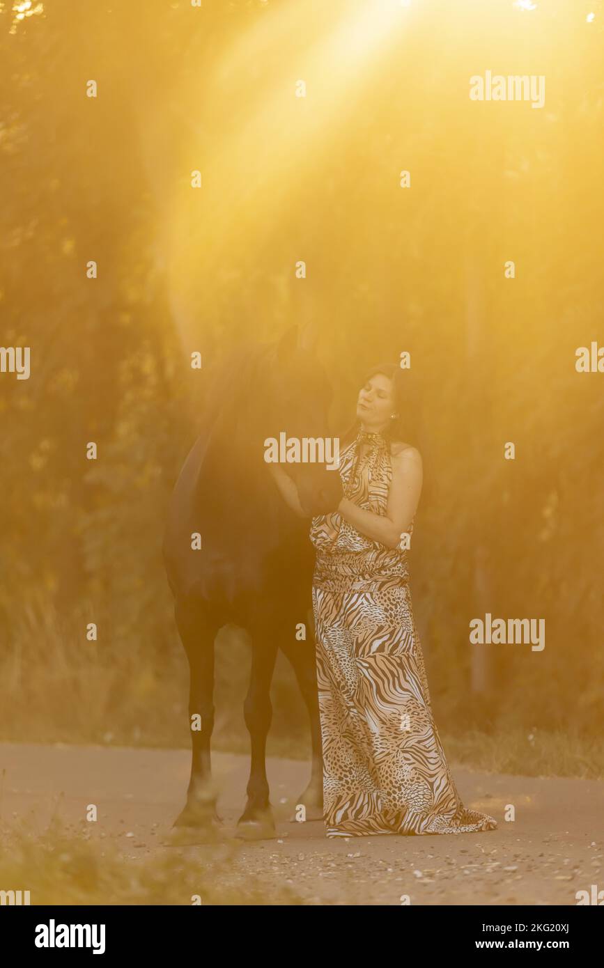 young woman with friesian mare Stock Photo - Alamy