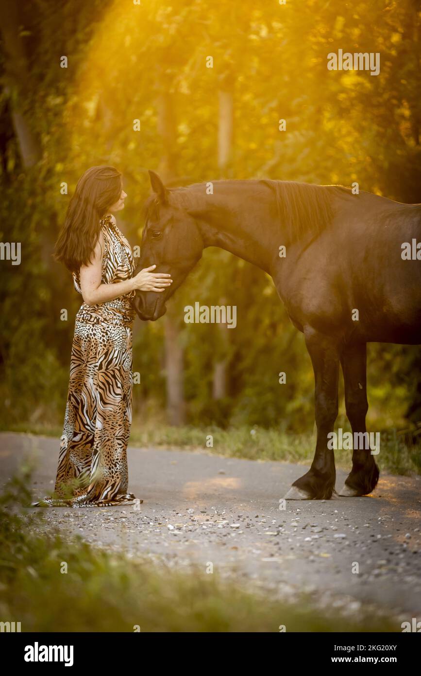 young woman with friesian mare Stock Photo - Alamy