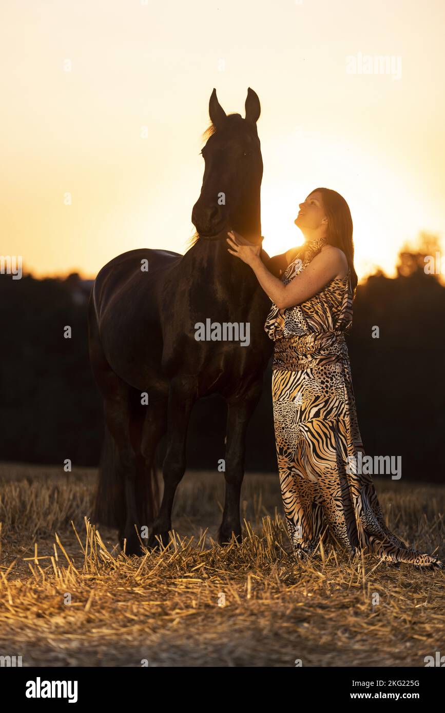 young woman with friesian mare Stock Photo - Alamy
