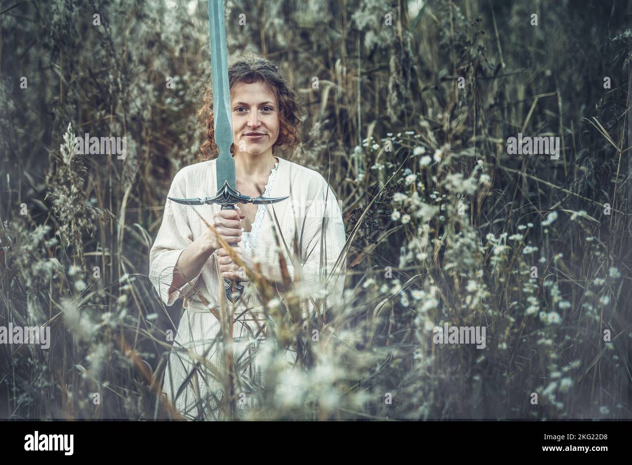 Beautiful woman in nature with a sword in her hand Stock Photo - Alamy
