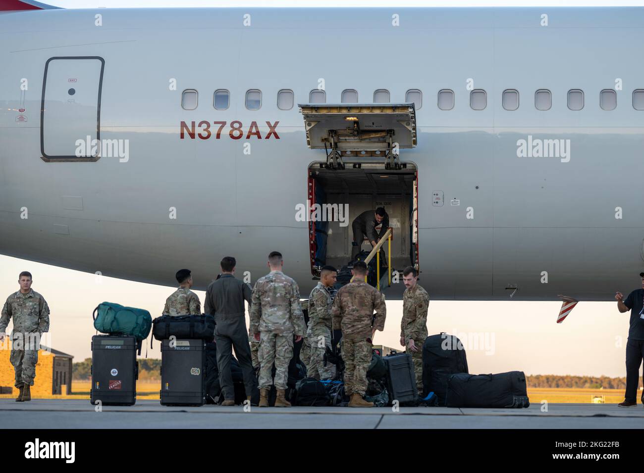 U.S. Air Force Airmen, assigned to the 23rd Wing, load baggage onto an ...