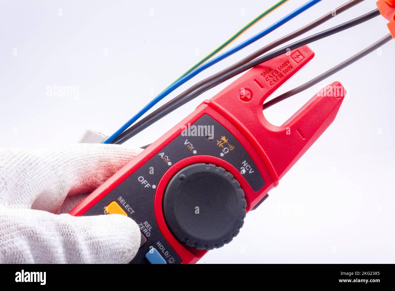 The electrician measures the current in the phase wire with a meter on ...