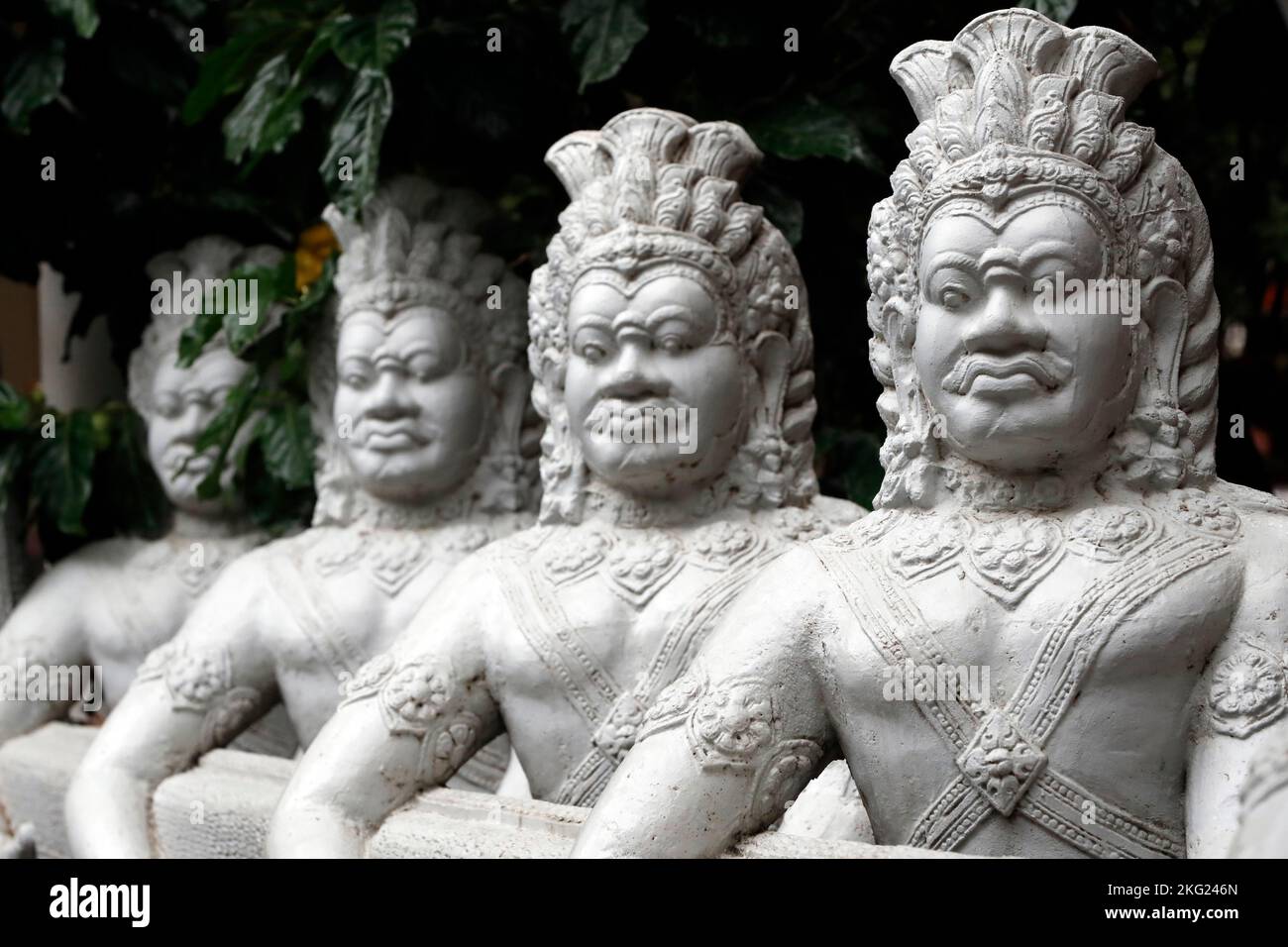 Wat Botum temple. Row of warrior statues carrying a giant serpent ...
