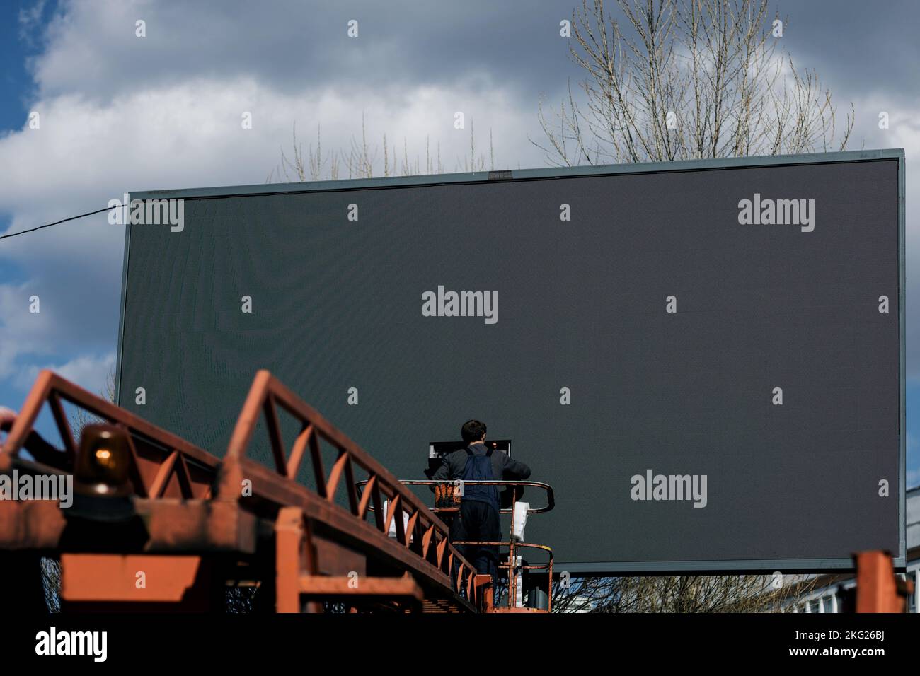 worker repair advertisement display. a man repairs the LED display ...