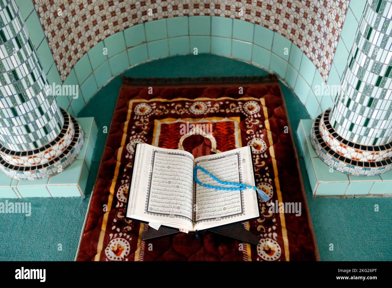 Mubarak mosque. Open Quran and muslim prayer beads on wood stand ...