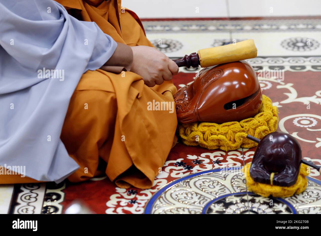 Thien Quang Co Tu buddhist temple. Nun playing on a wooden fish ...