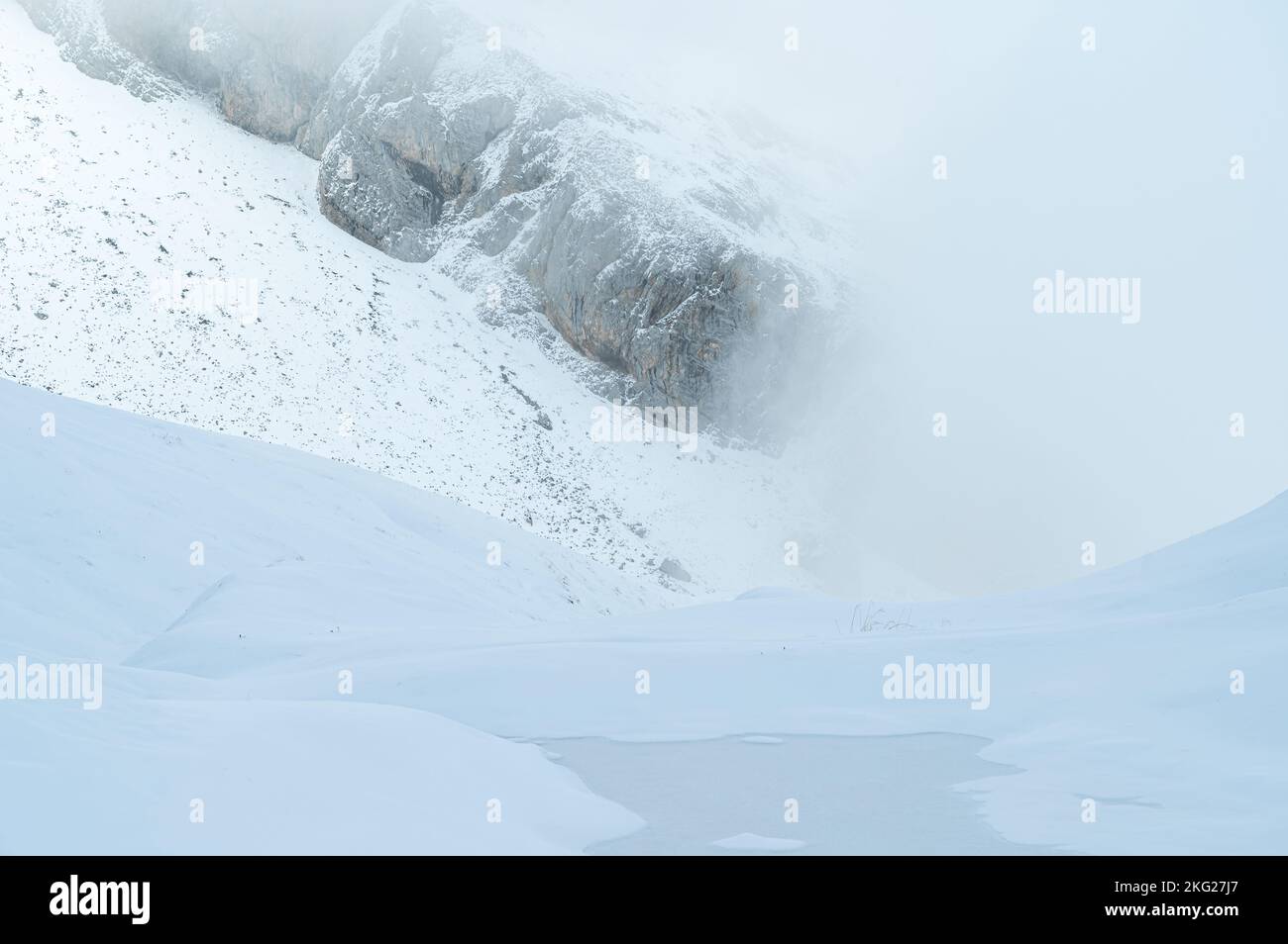 Foggy snow capped mountain and frozen lake Stock Photo - Alamy