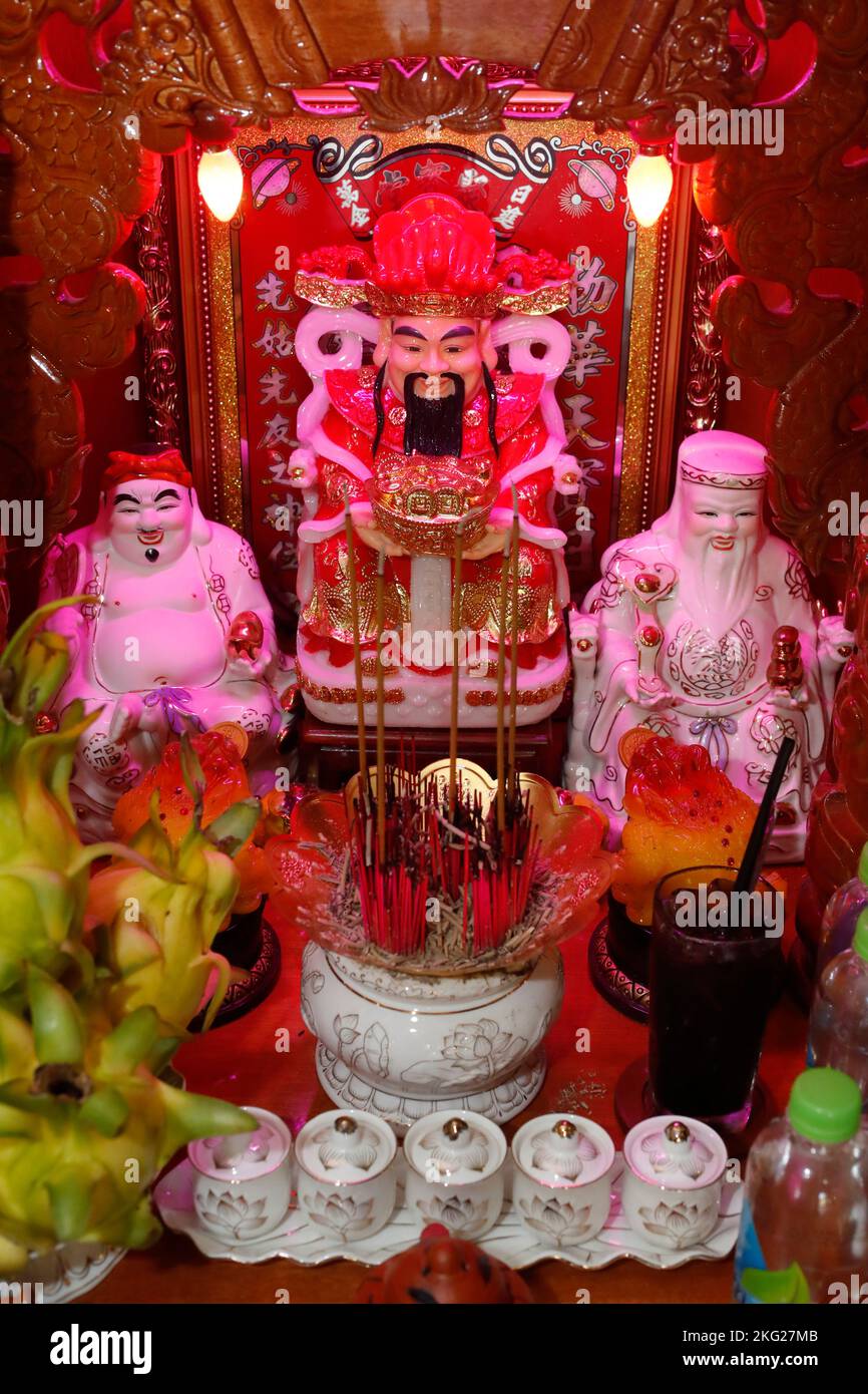 Traditional chinese shrine in a restaurant. Offerings an incense sticks ...