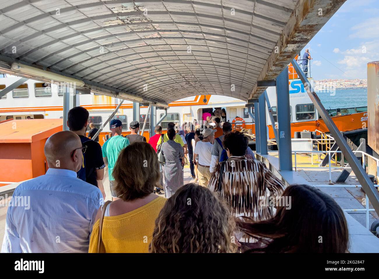 Queue of people embarking on boat at Cacilhas Stock Photo - Alamy