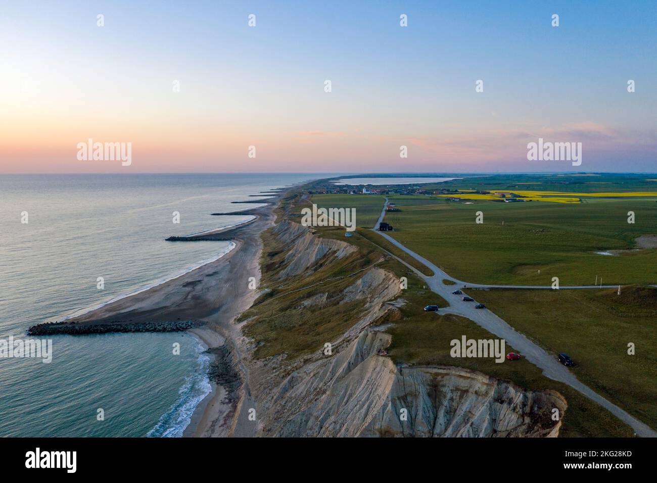 The gradient blue sky over the sea and green fields captured at sunset ...