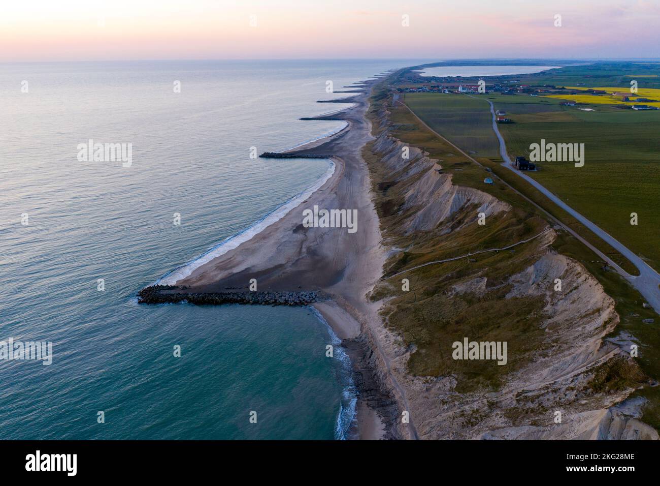 The gradient blue sky over the sea and green fields captured at sunset ...