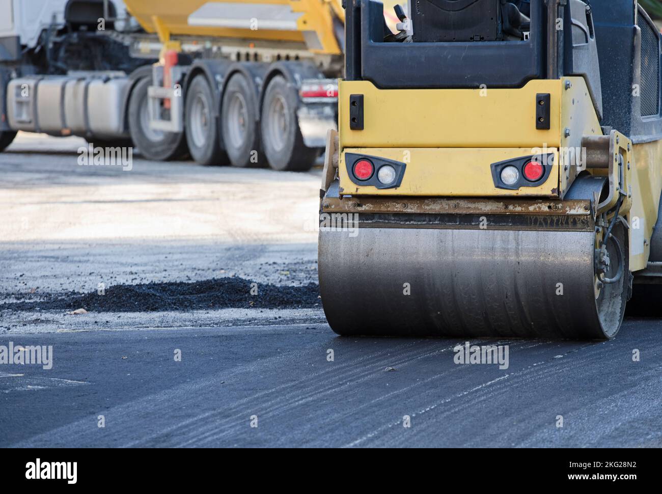 Road roller and asphalt paving machine at construction site Stock Photo ...