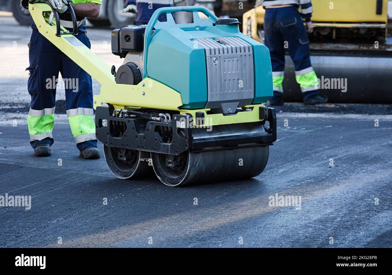 Road construction equipment flattening and smoothing asphalt black top ...