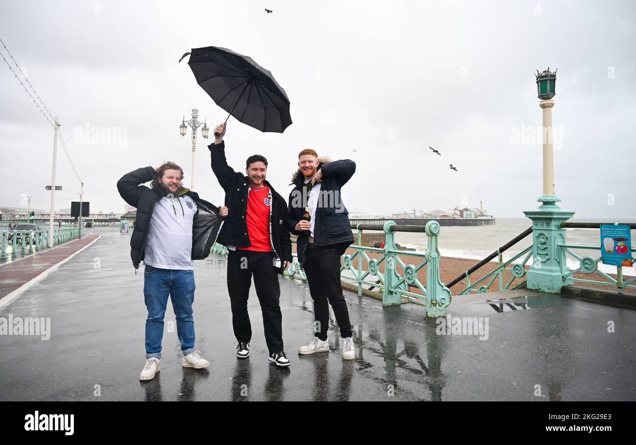 Brighton UK 21st November 2022 - England fans battle the wind and rain ...
