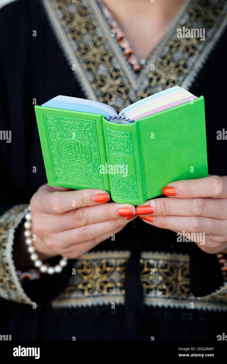 Muslim woman reading a green Holy Quran in arabic. Close up Stock Photo ...
