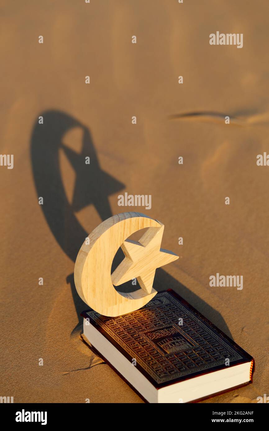 An arabic Quran and a shadow on the sand at sunset of a crescent and a ...
