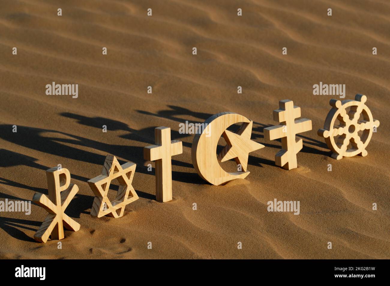 Religious symbols on sand at sunset : Catholic, Islam, Judaism ...