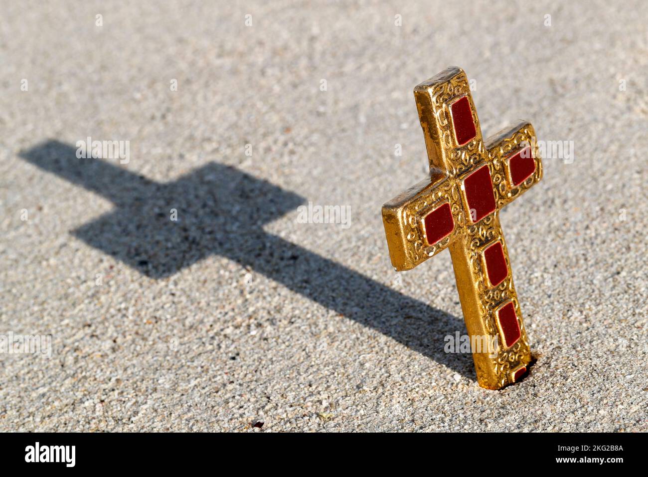 A shadow of a wooden christian cross in the sand. Symbol of ...