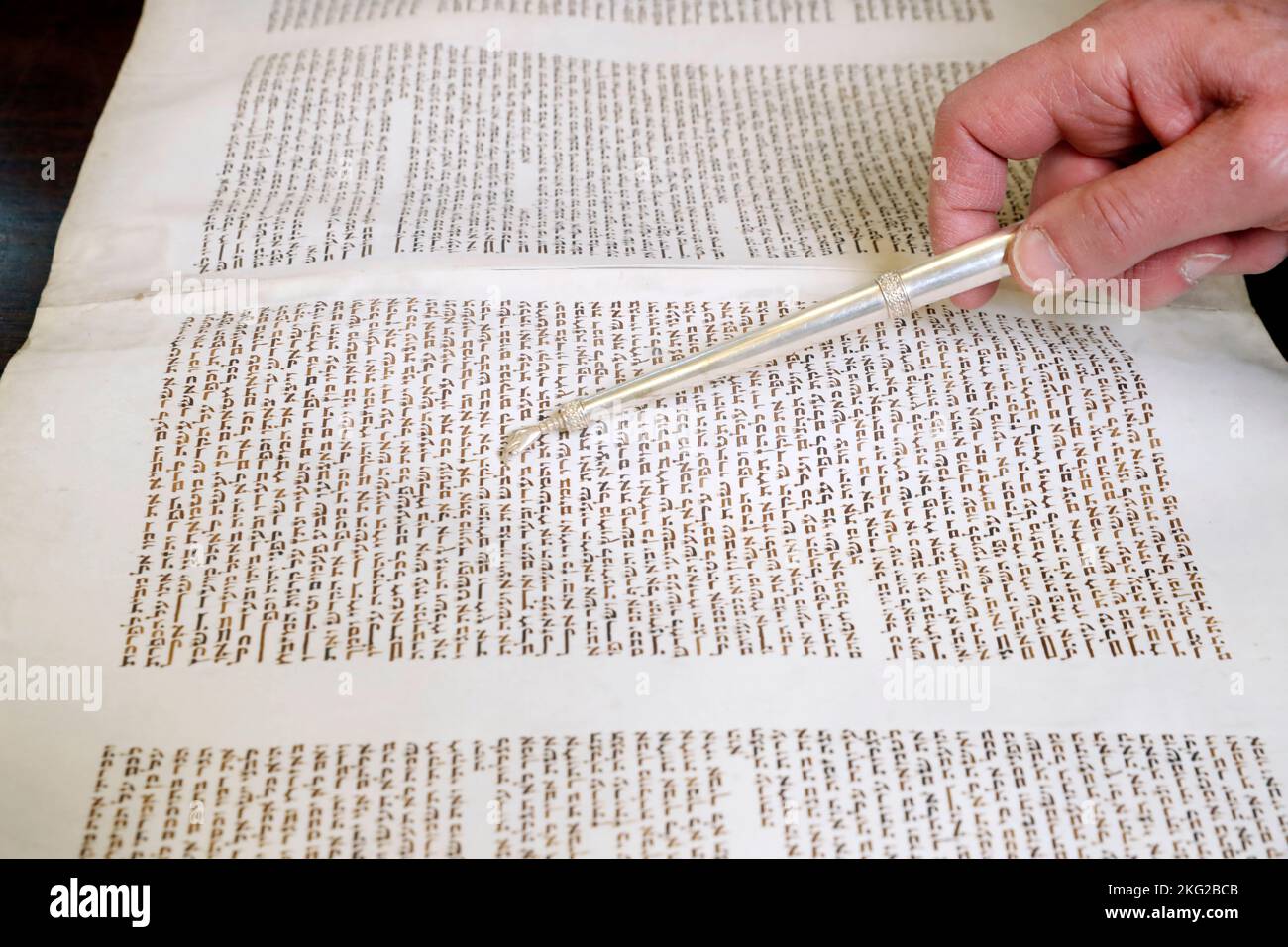 Rabbin holding a yad, reading an ancient Torah scroll. Yom Kippur Stock ...