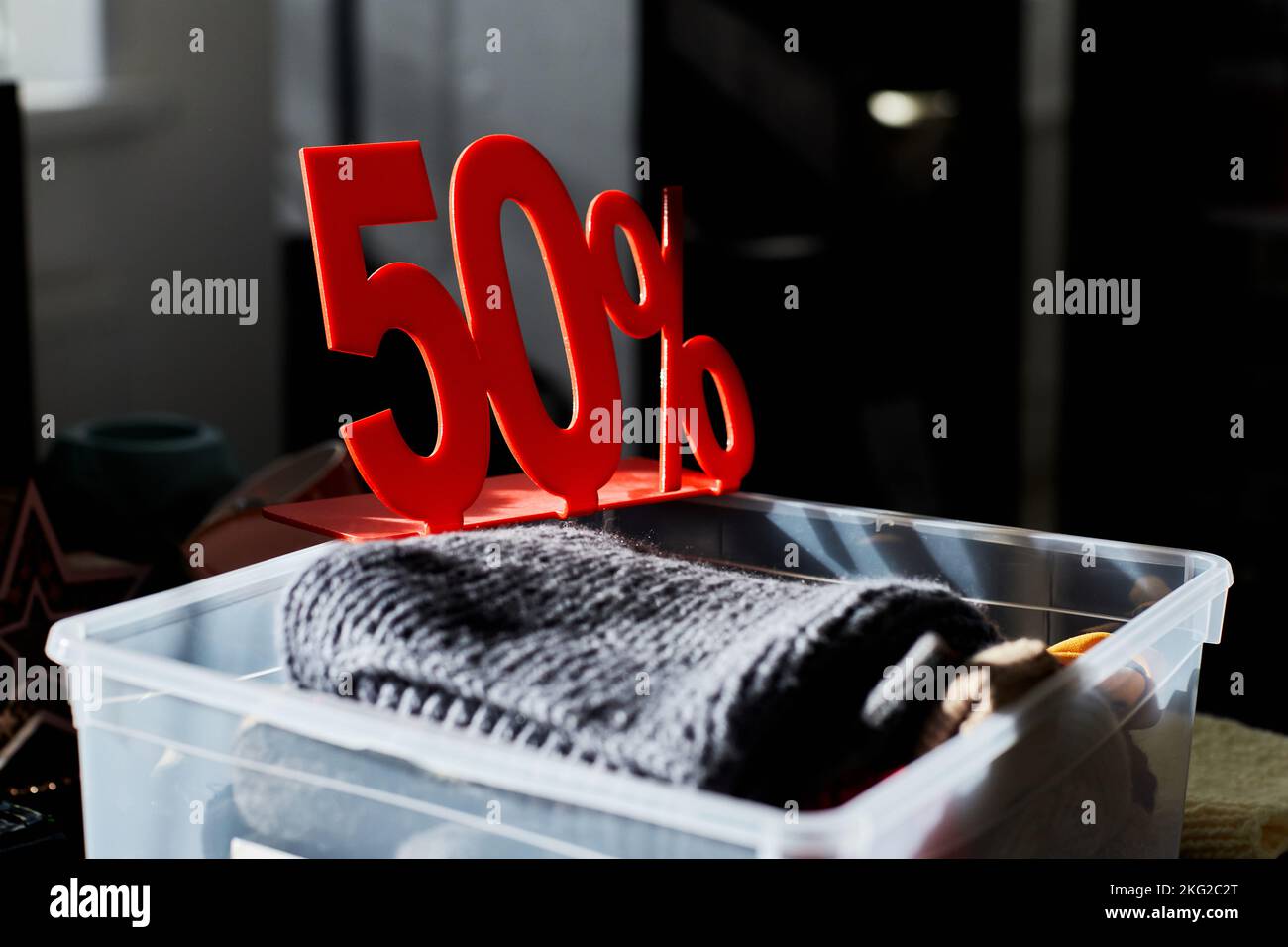 Close up of clothes bin in second hands store with 50 percent off sale ...