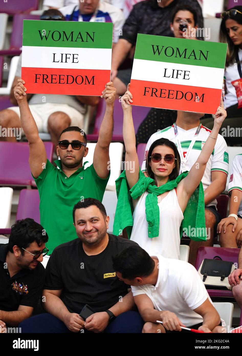 Iran fans in the stands hold up signs reading "Woman Life Freedom ...