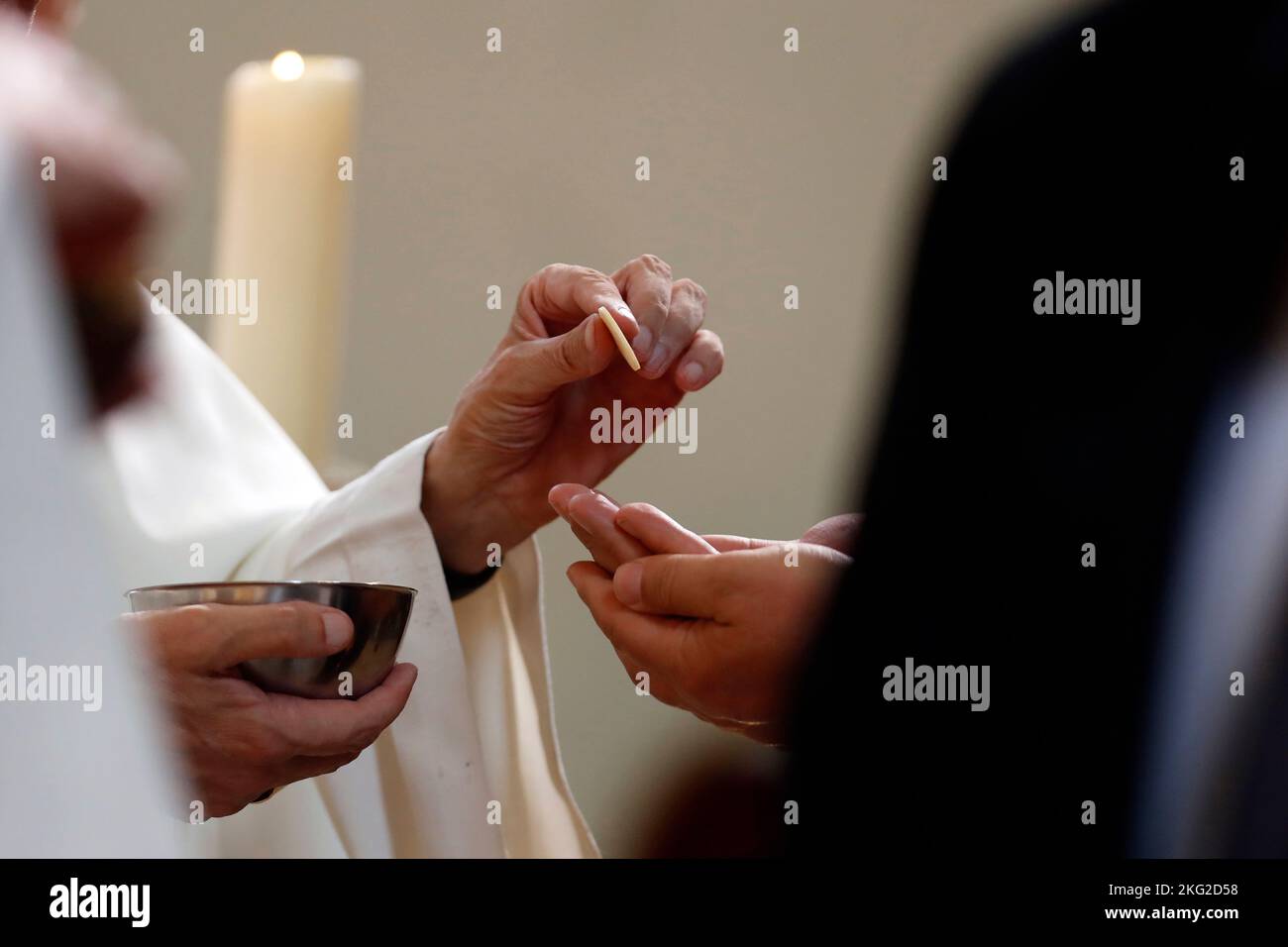 Sunday mass in a catholic parish. Priest giving Holy Communion ...