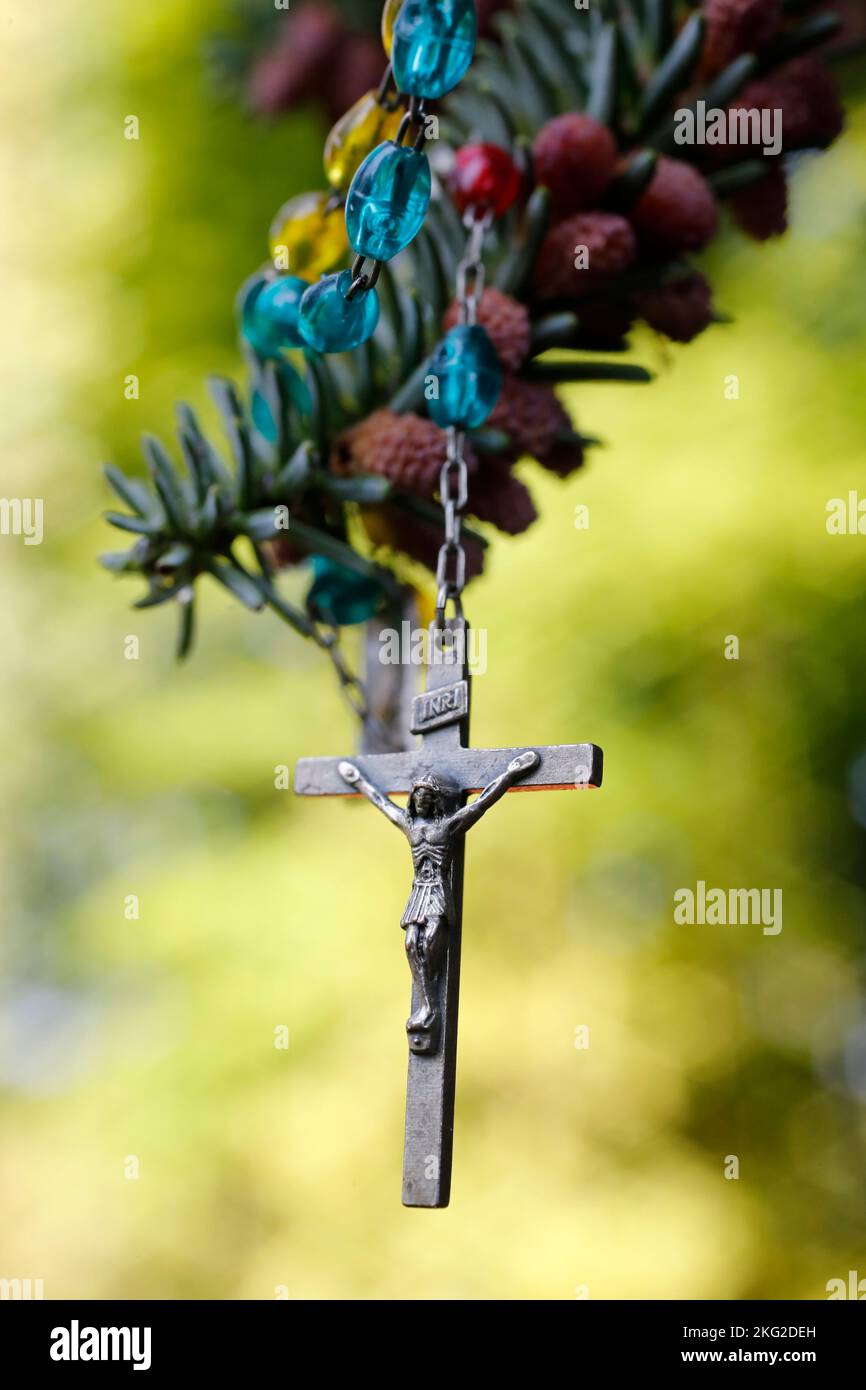 Catholic Rosary with Jesus on the cross on a pine tree branch. Ecology ...